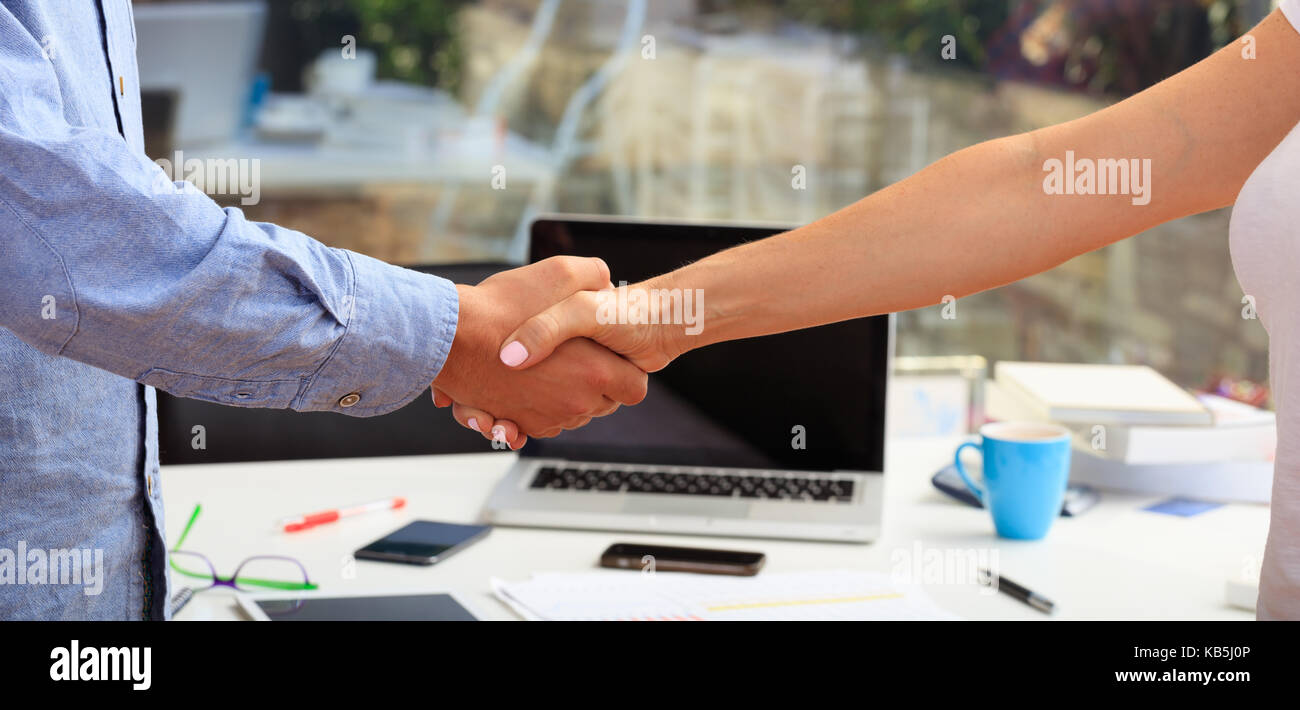 Business handshake in an office background Stock Photo - Alamy