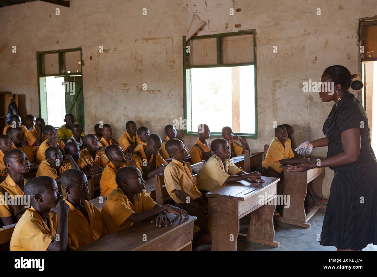 A female teacher teaching science to a classroom of students at a ...