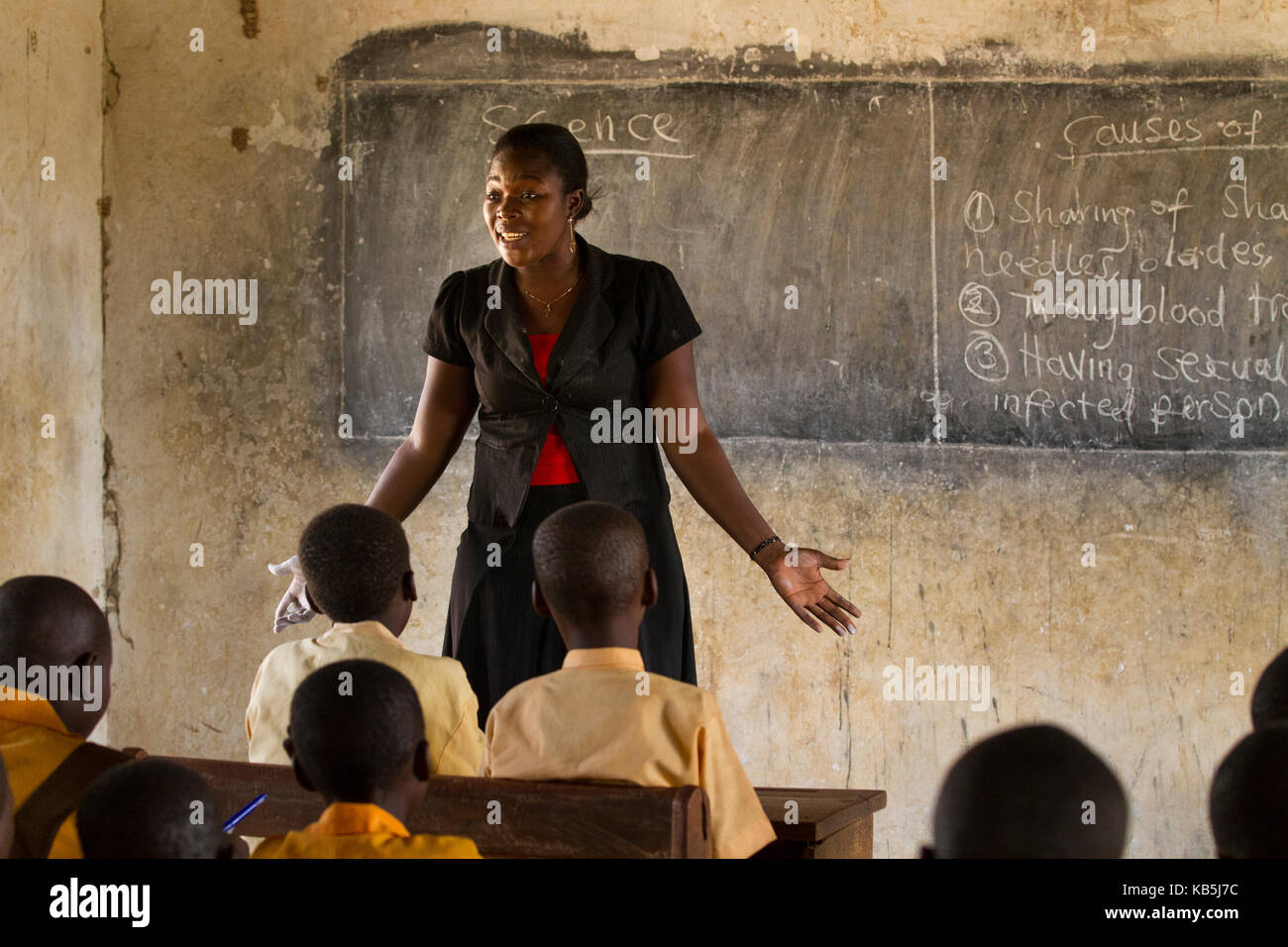 A female teacher teaching science to a classroom of students at a ...