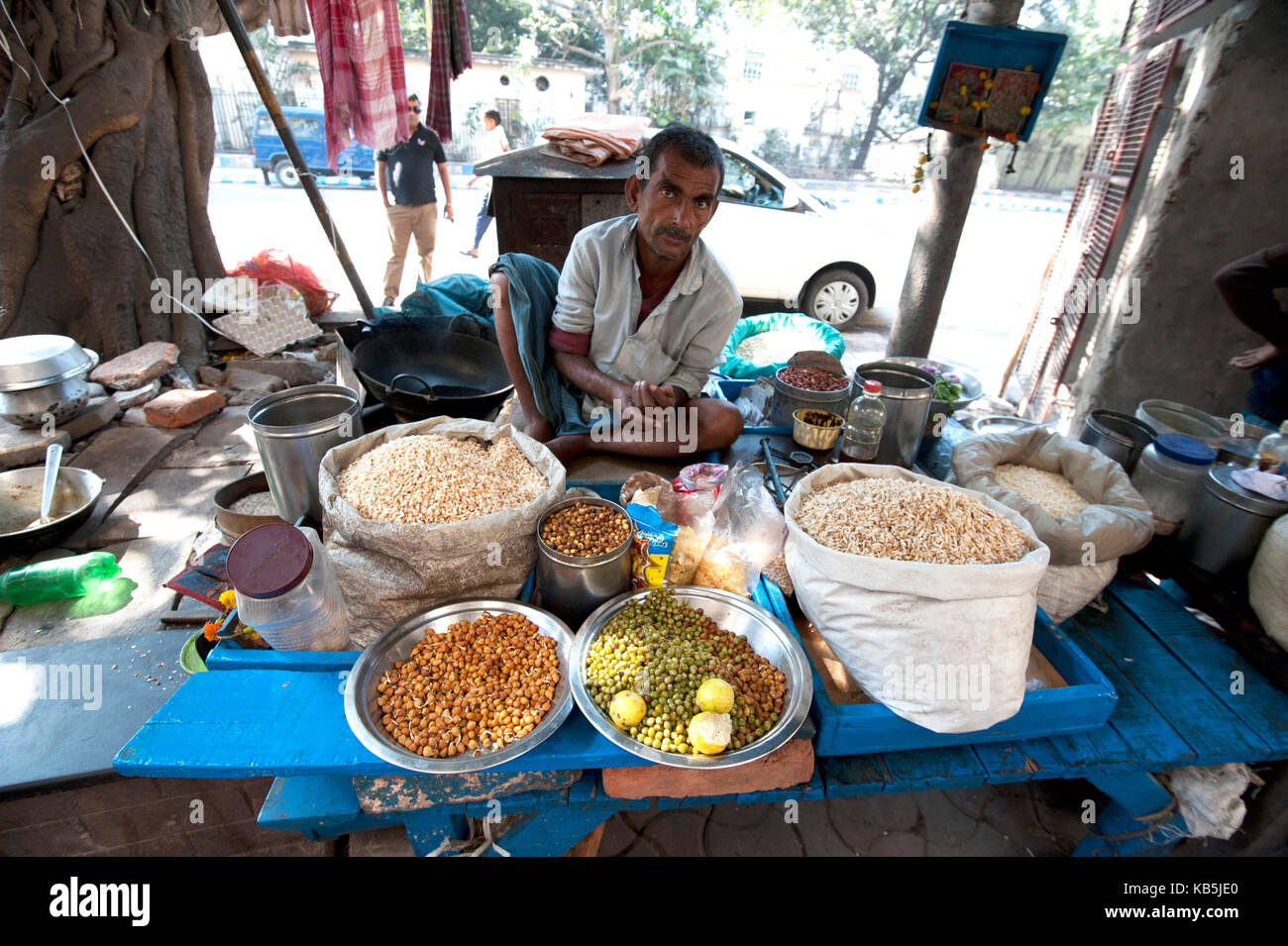 Chaat stall, man mixing sprouting seeds and lentils and puffed rice ...