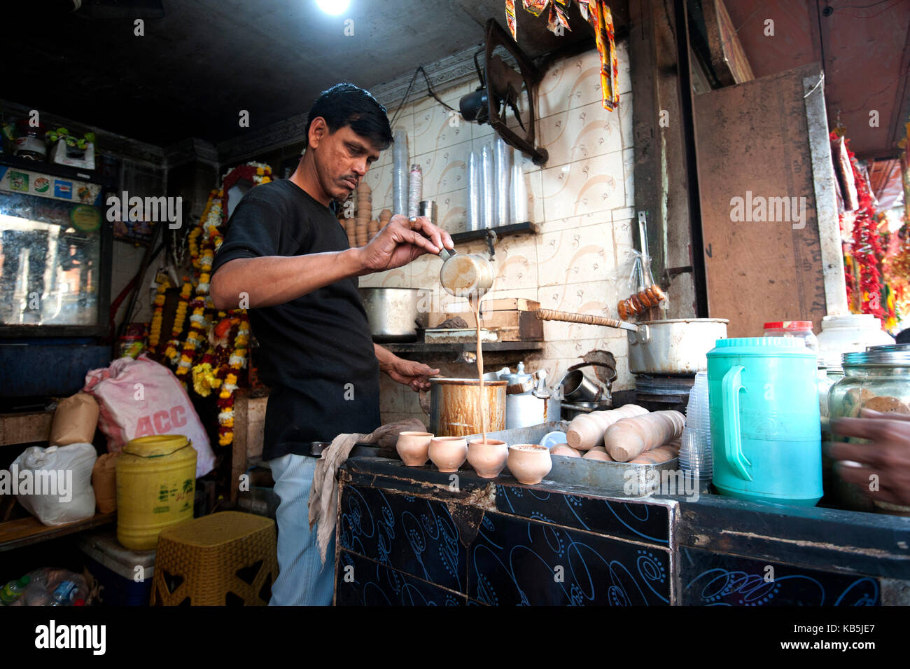 Chai wallah, pouring Indian chai into terracotta clay cups, in chai ...