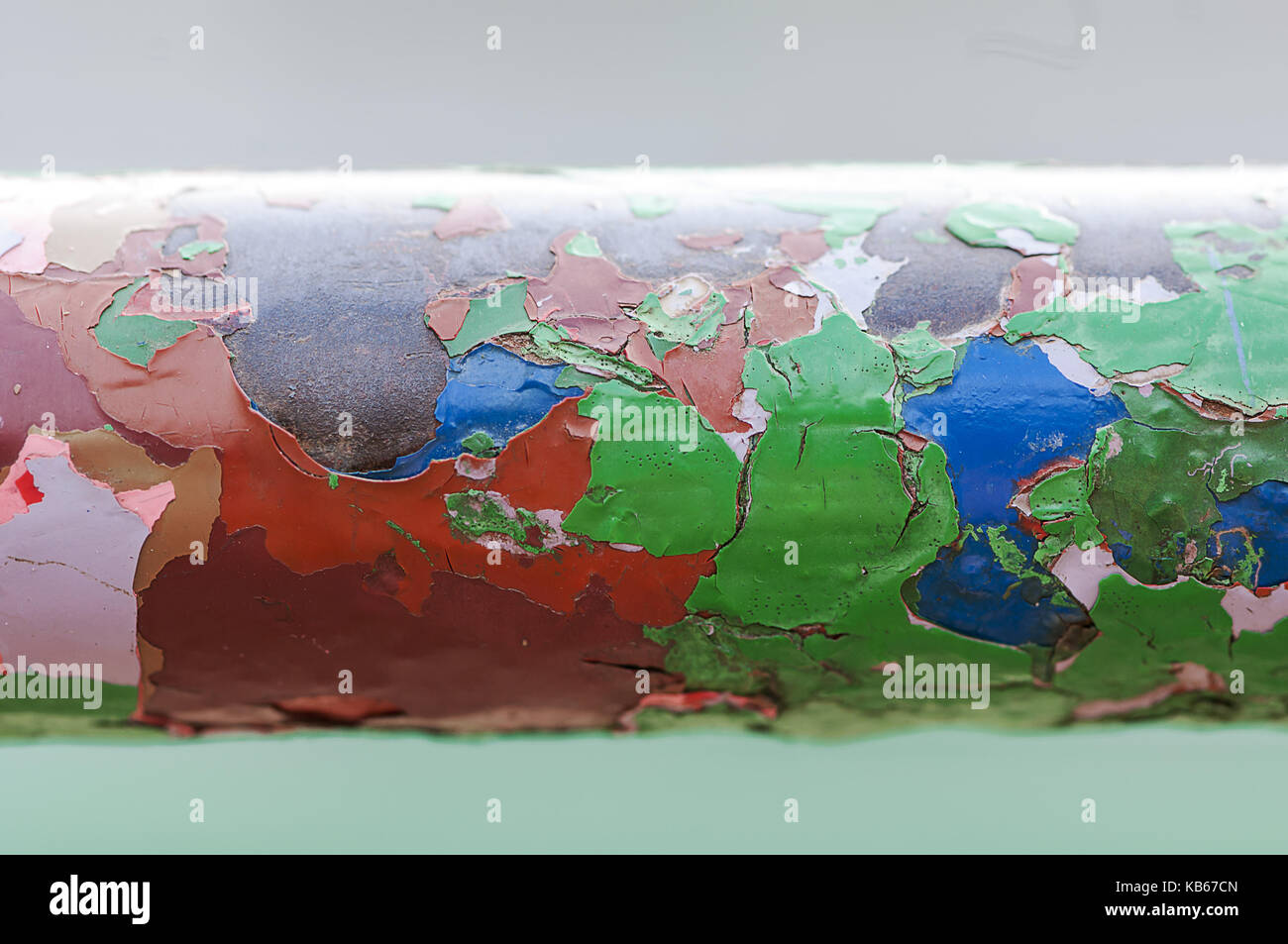 Peeling paint on a metal bar. Multiple layers of colored paint Stock ...