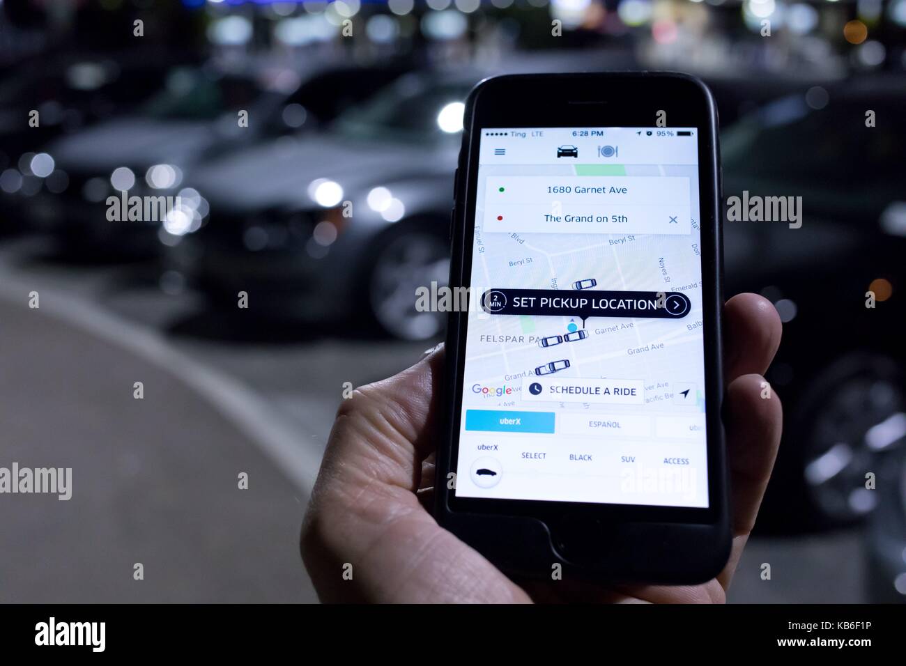 Hand holding an iPhone 6 with the Uber app, showing a map with ...