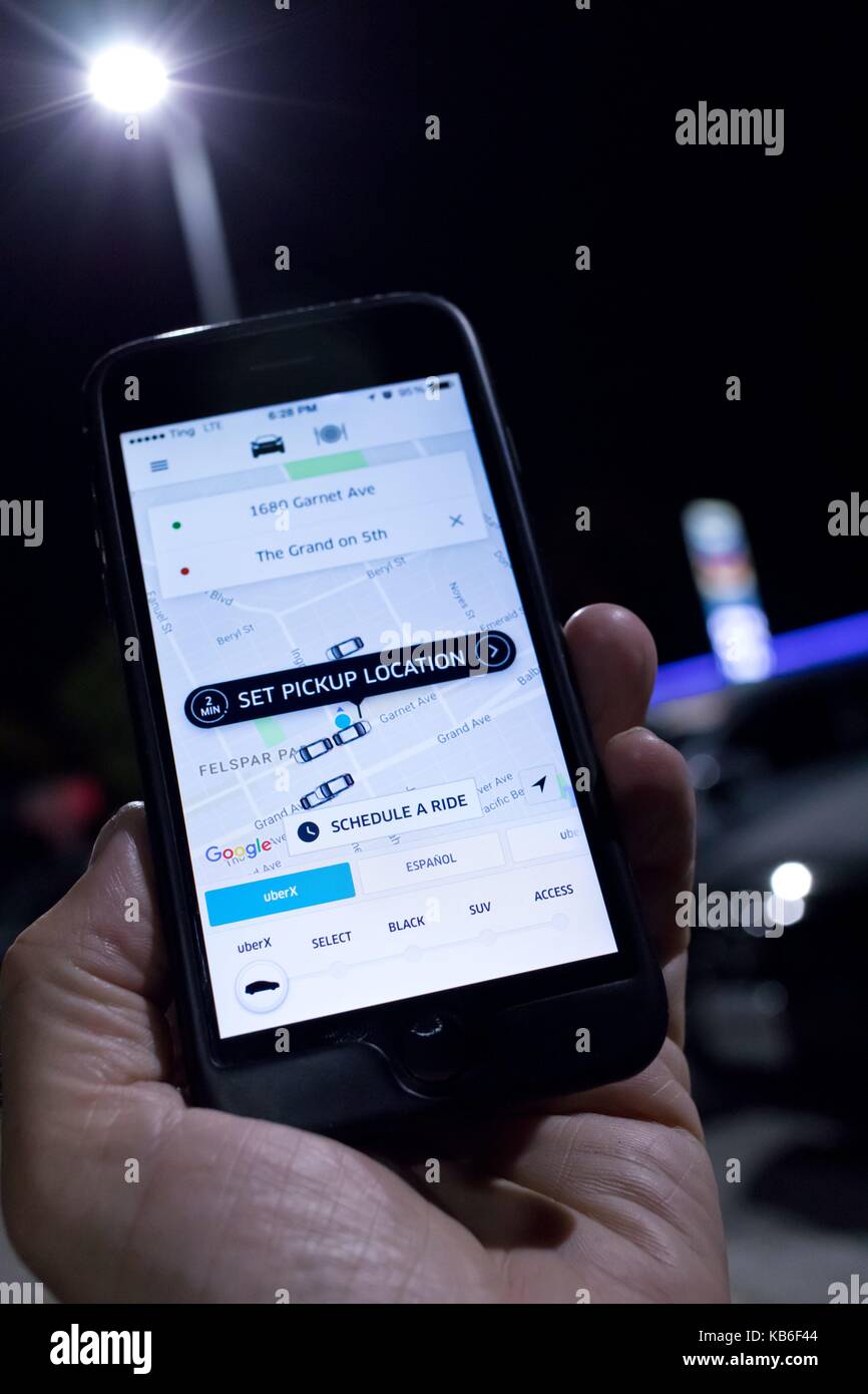 Hand holding an iPhone 6 with the Uber app, showing a map with ...