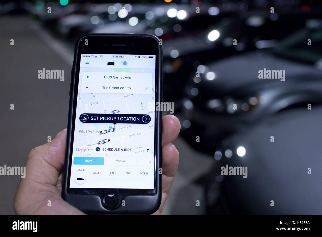 Hand holding an iPhone 6 with the Uber app, showing a map with ...