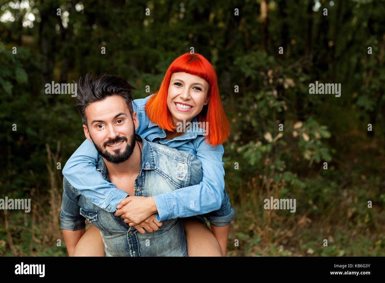 Handsome guy giving piggyback ride to girlfriend in a park Stock Photo ...