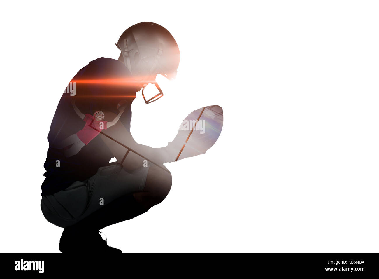 Profile view of American football player in attack stance against white ...