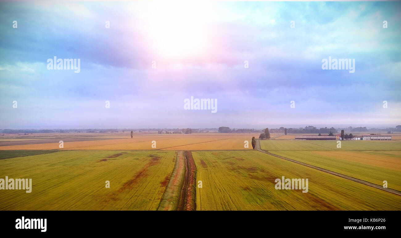 Sun between clouds lighting green grass field Stock Photo - Alamy
