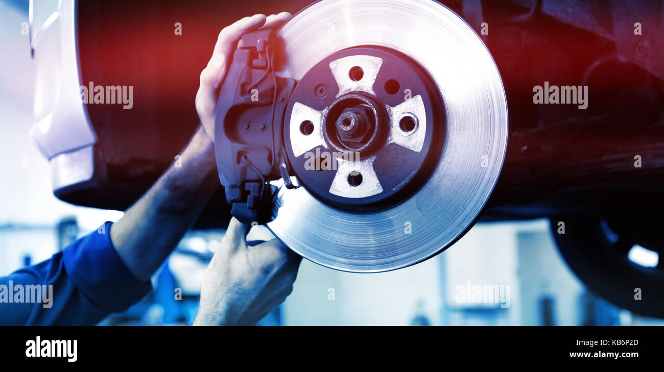 Cropped image of focused mechanic adjusting wheel at garage Stock Photo ...