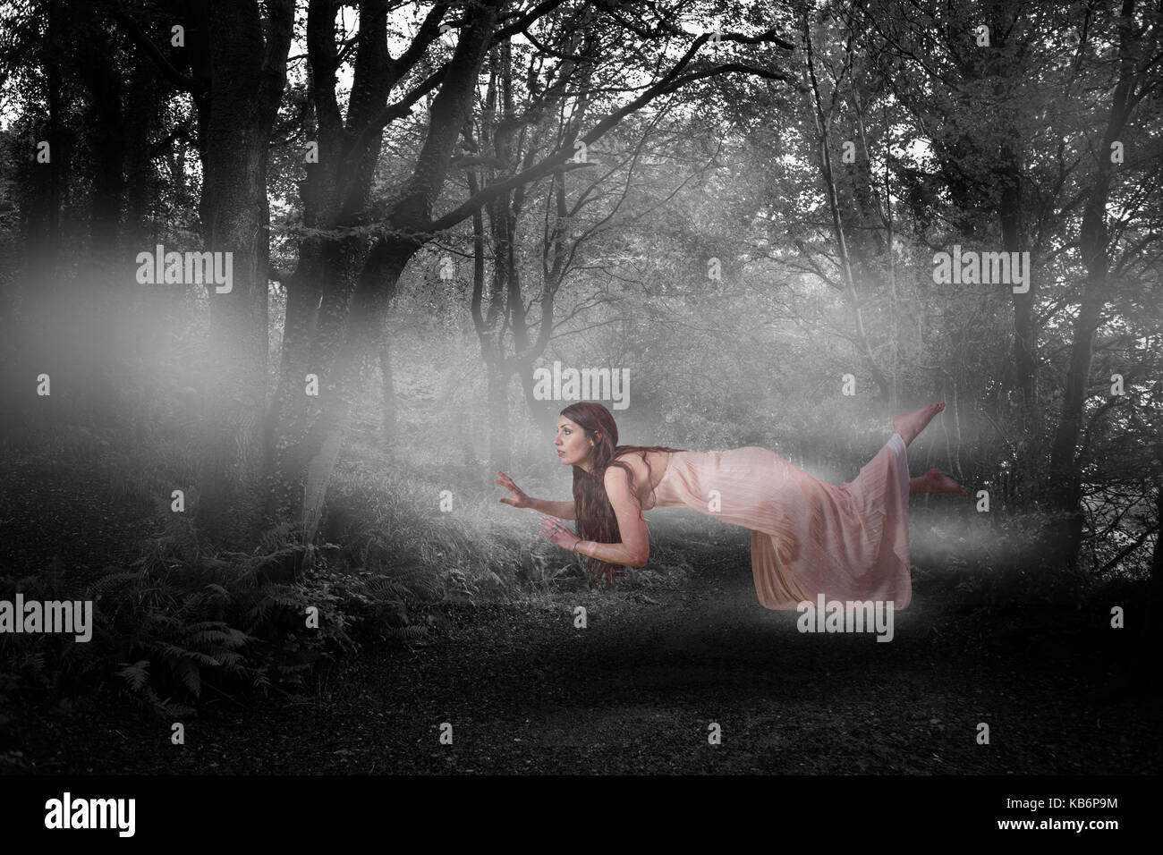 Full length of woman levitating against way between trees Stock Photo ...