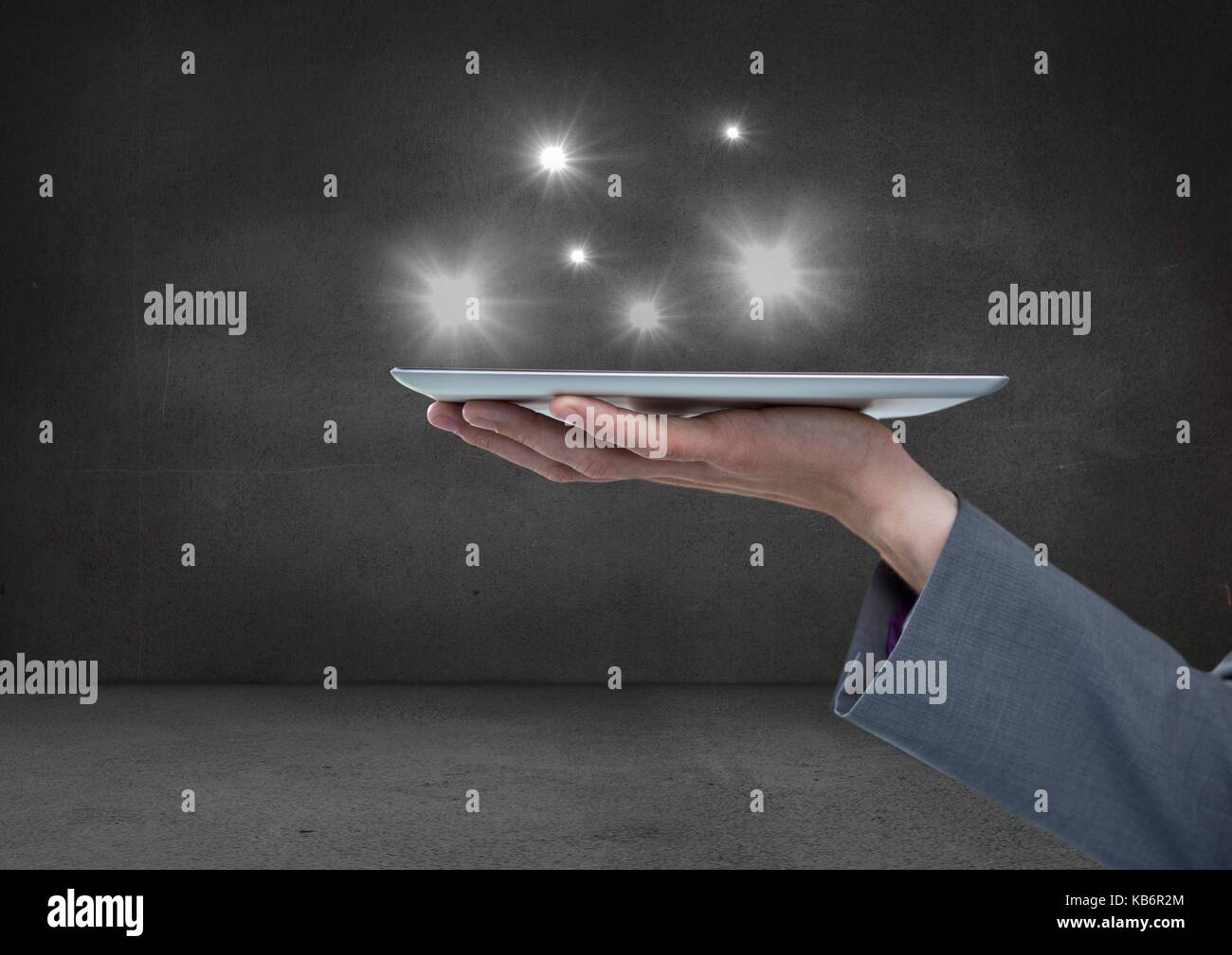 Digital composite of Hand holding tablet with glowing particles Stock ...