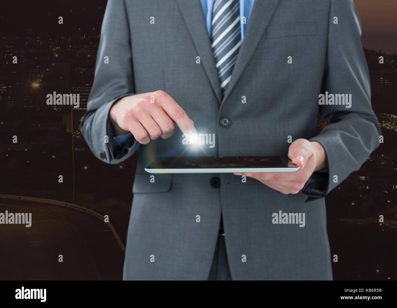 Digital composite of Hand touching tablet with glow Stock Photo - Alamy