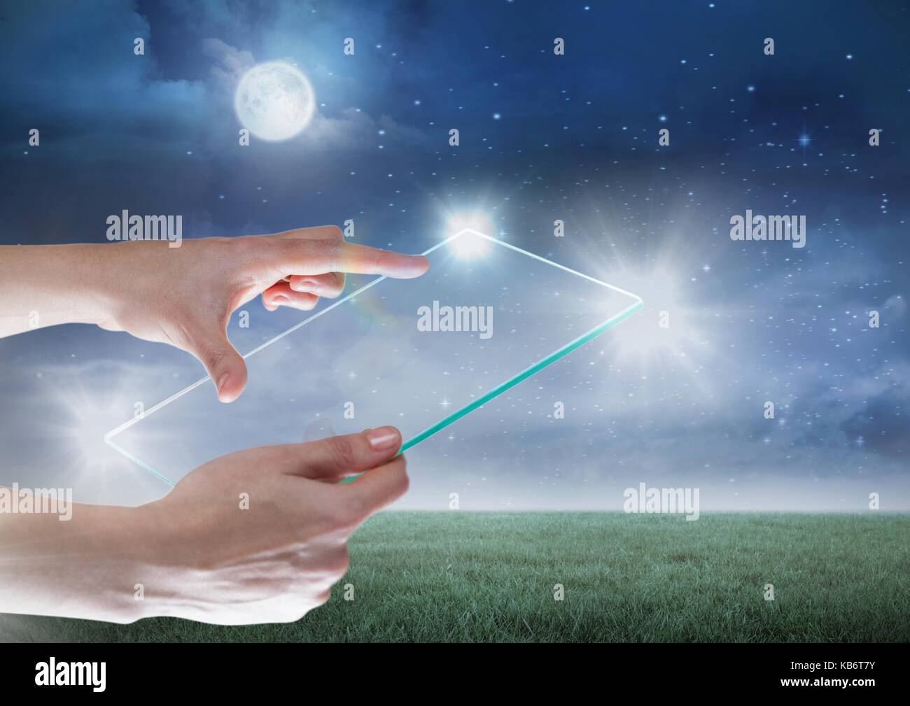 Digital composite of Hand holding glass tablet with glow and moon Stock ...