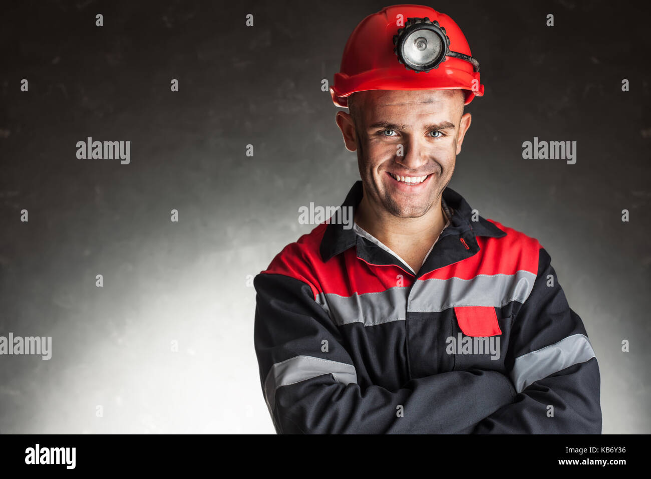 Portrait of happy smiling coal miner with his arms crossed against a ...
