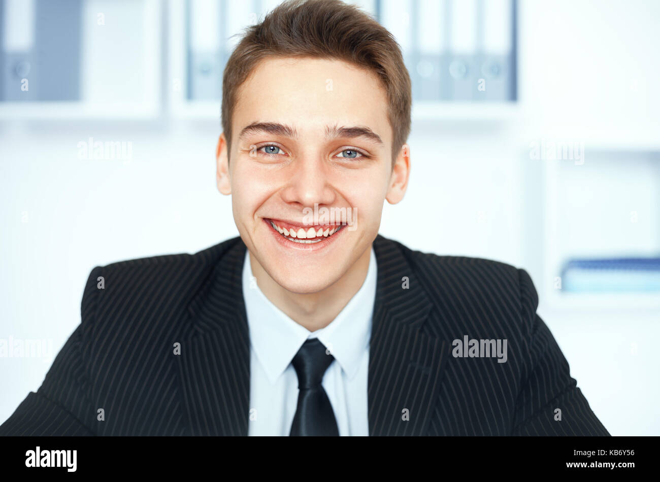 Portrait of young businessman laughing in bright office Stock Photo - Alamy