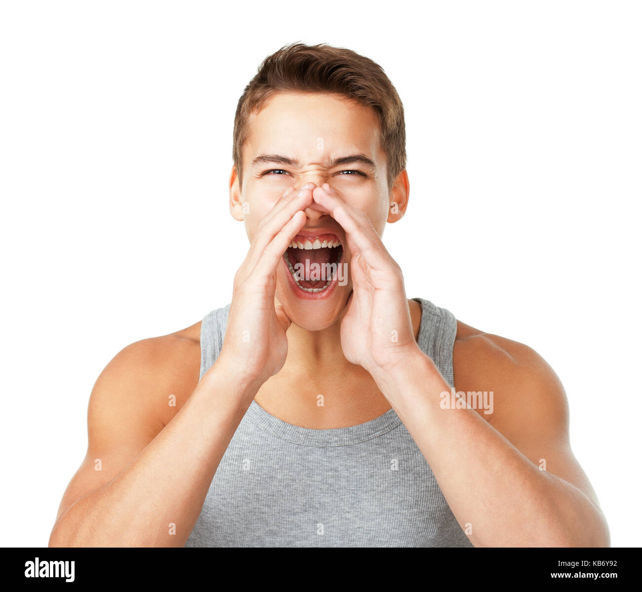 Young man wearing a gray T-shirt shouting through hands isolated on ...