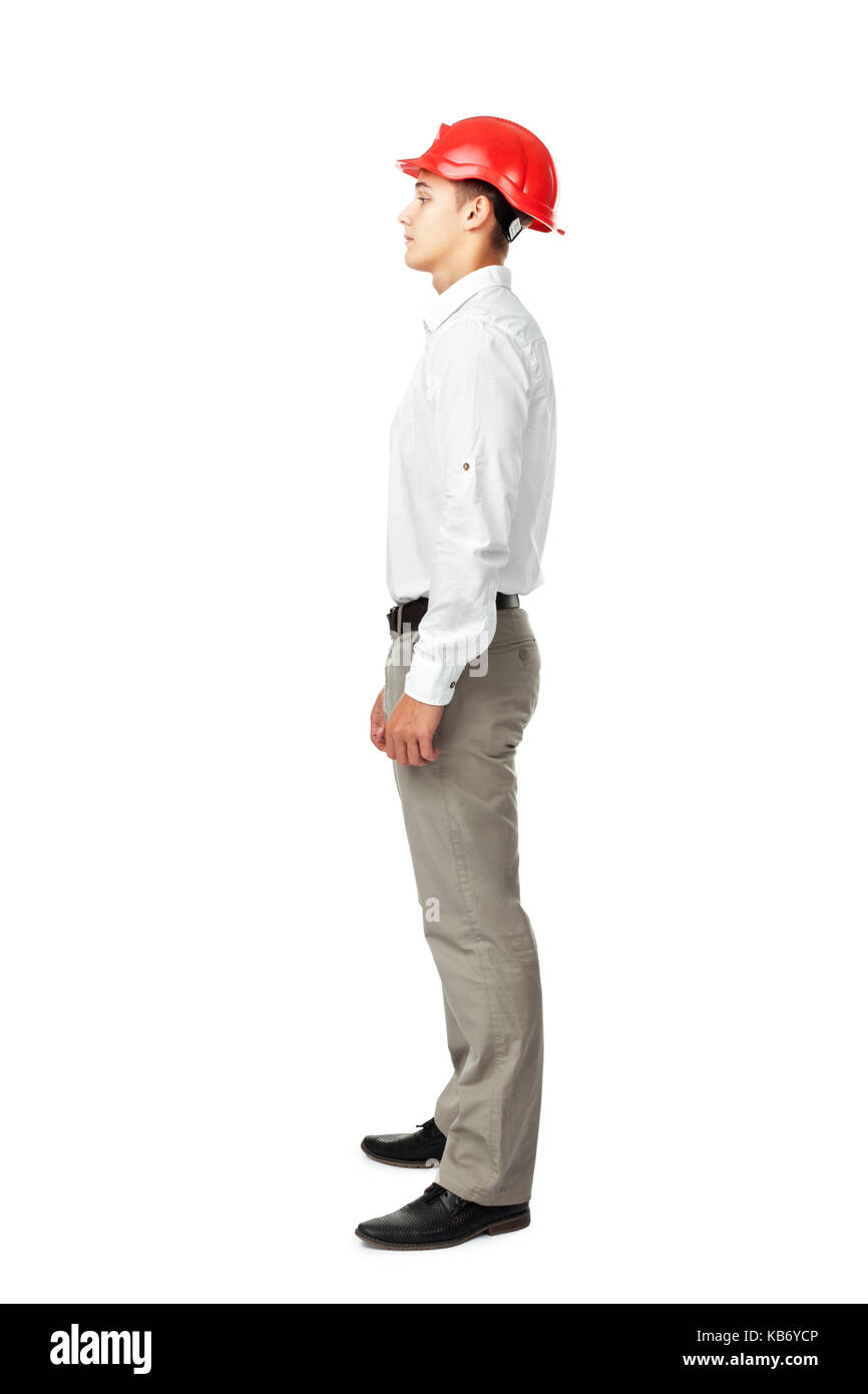 Full length side view portrait of young engineer wearing a red helmet ...