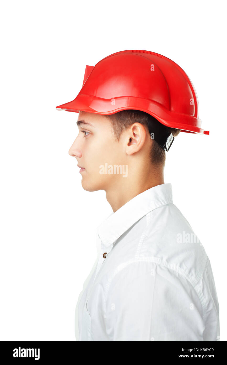 Side view portrait of young engineer wearing a red helmet isolated on ...