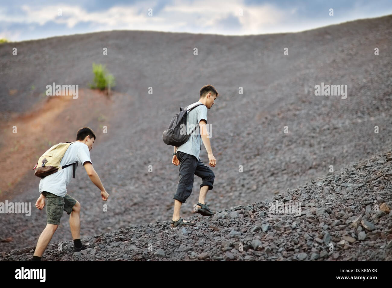 Two young tourist men walks on stones and rock slope Stock Photo - Alamy
