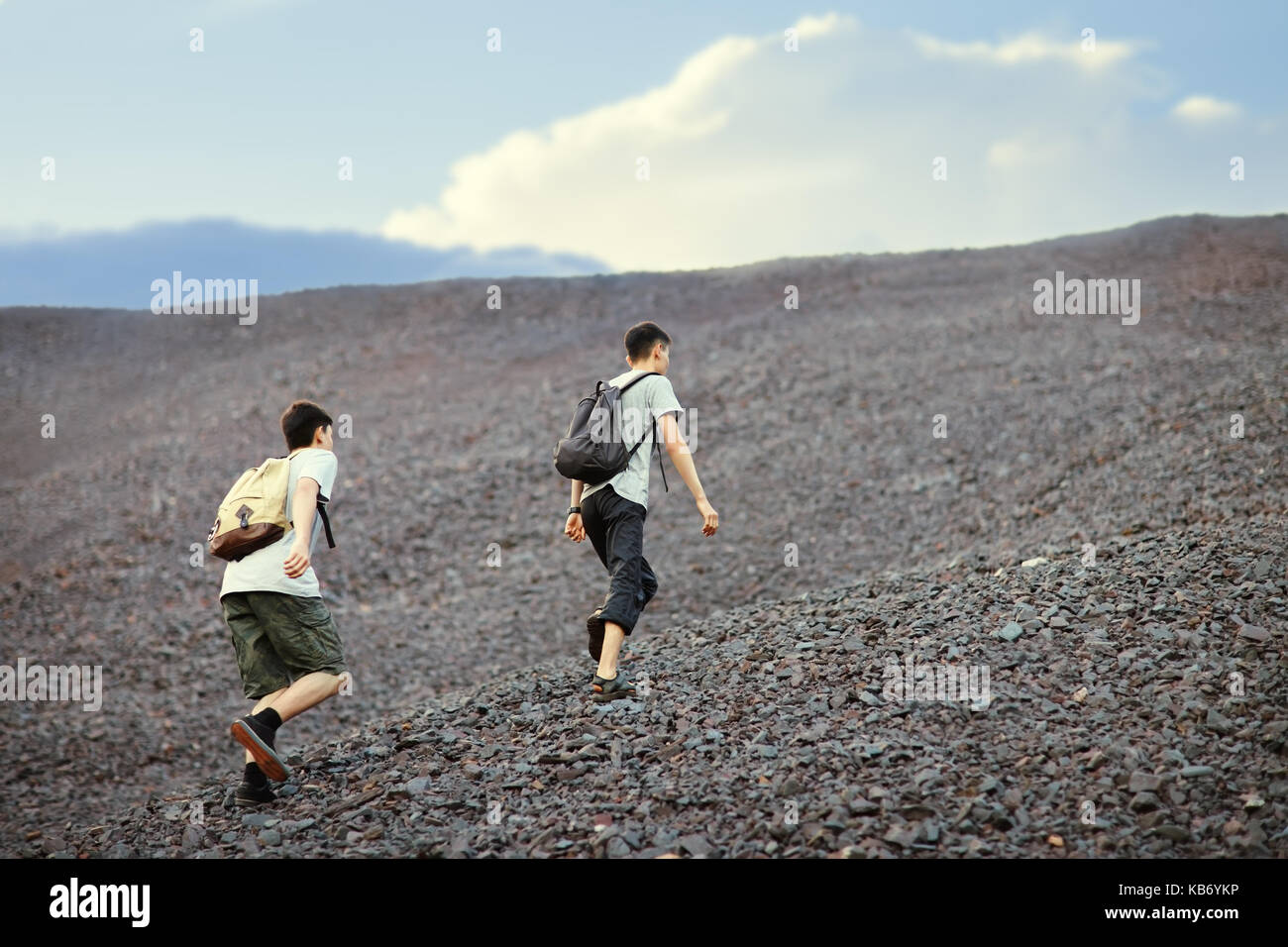 Two young tourist men walks on stones and rock slope Stock Photo - Alamy
