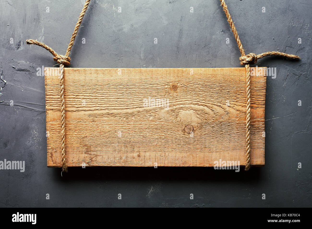 Wooden signboard hanging on rope on gray textured wall Stock Photo - Alamy