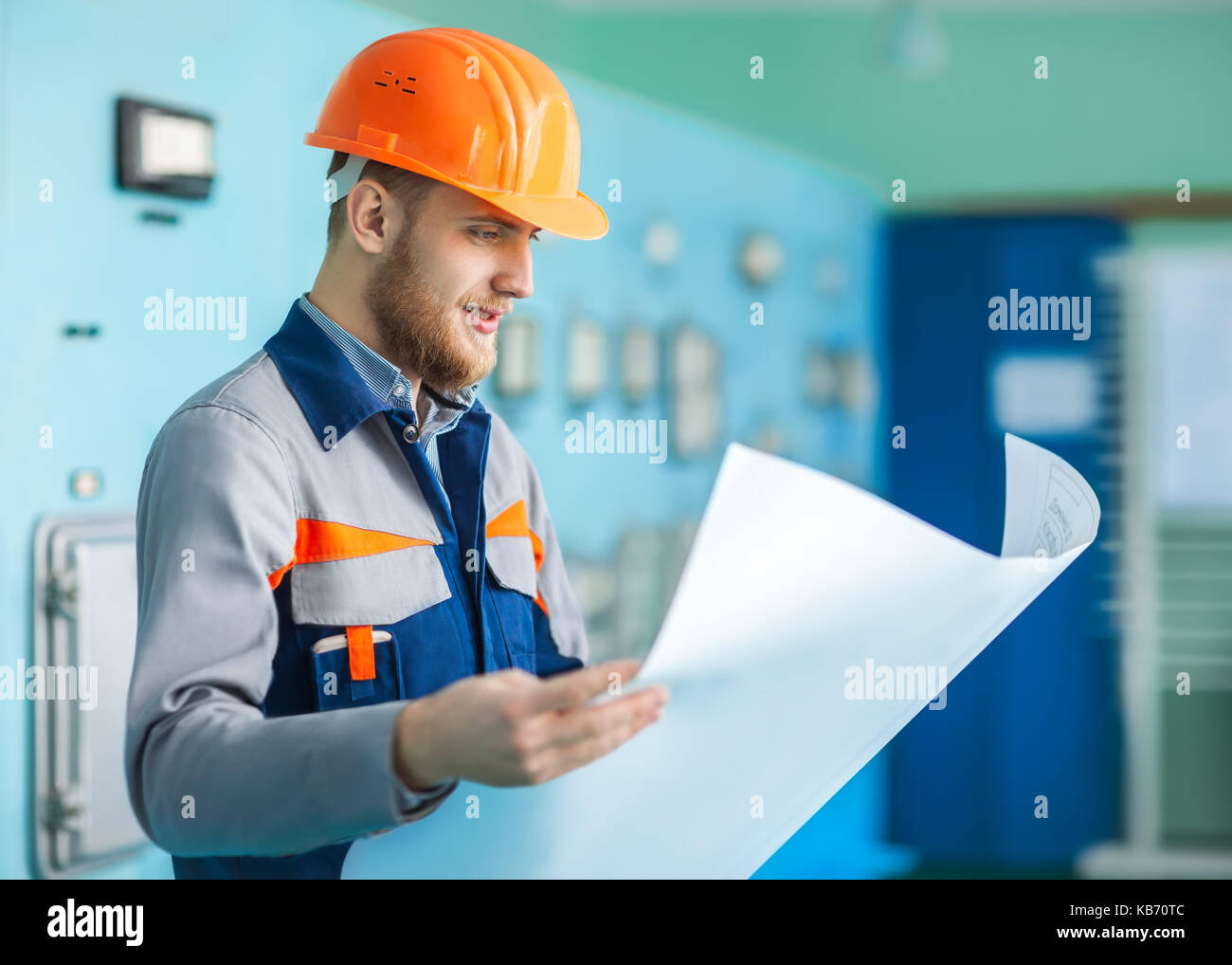 Portrait Of Young Engineer Working With Blueprint At Control Room Stock