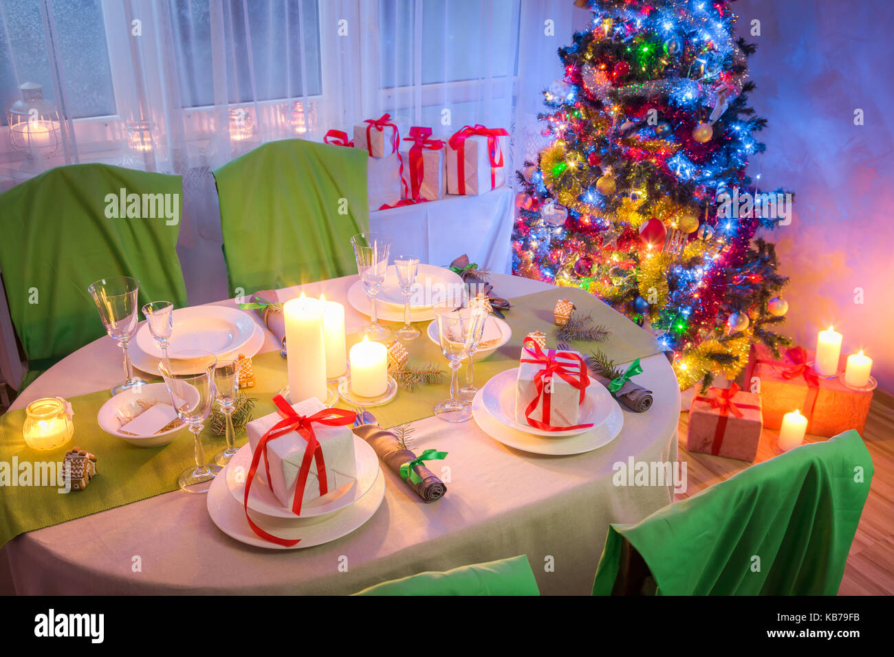 Family Christmas table setting with present and tree Stock Photo - Alamy