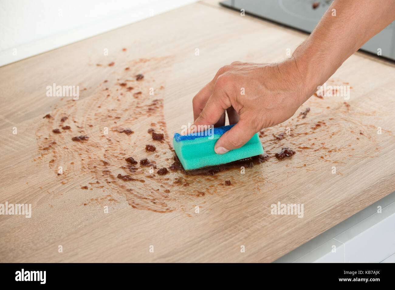 Cropped image of man cleaning kitchen counter with sponge Stock Photo ...