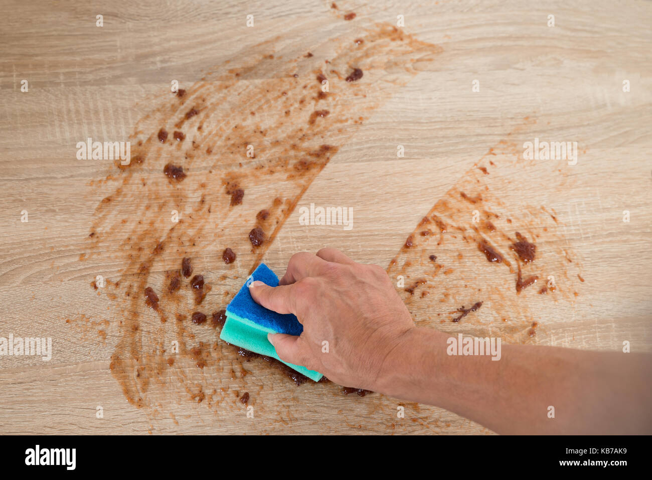 Cropped image of man cleaning kitchen counter with sponge Stock Photo ...