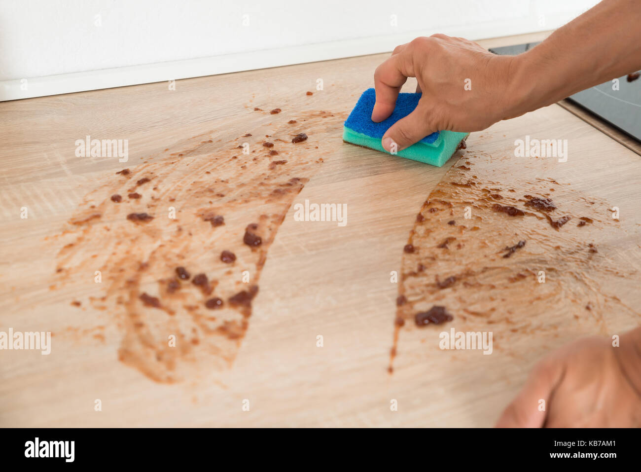 Cropped image of man cleaning kitchen counter with sponge Stock Photo ...