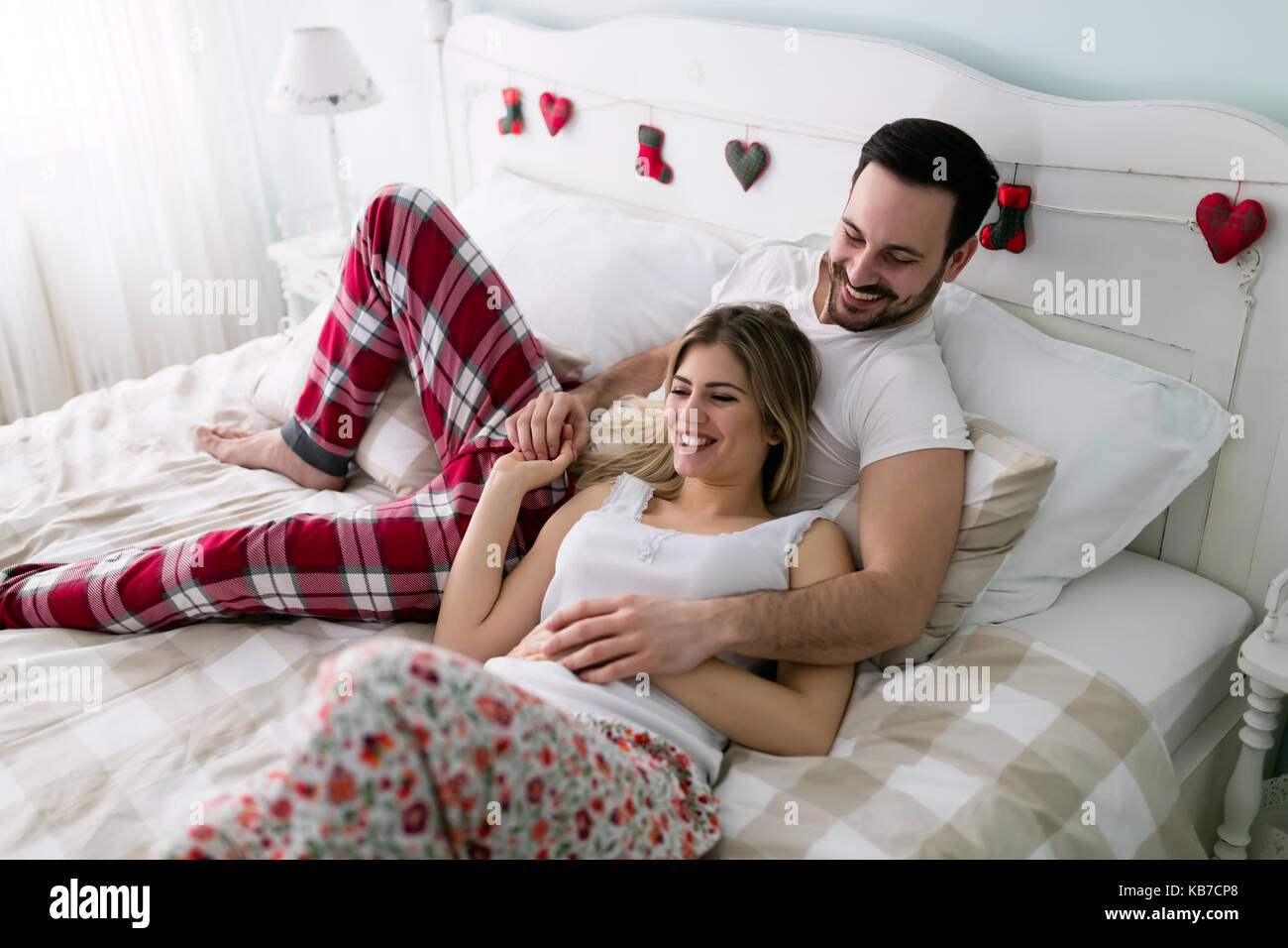 Young attractive couple having romantic time in bed Stock Photo - Alamy