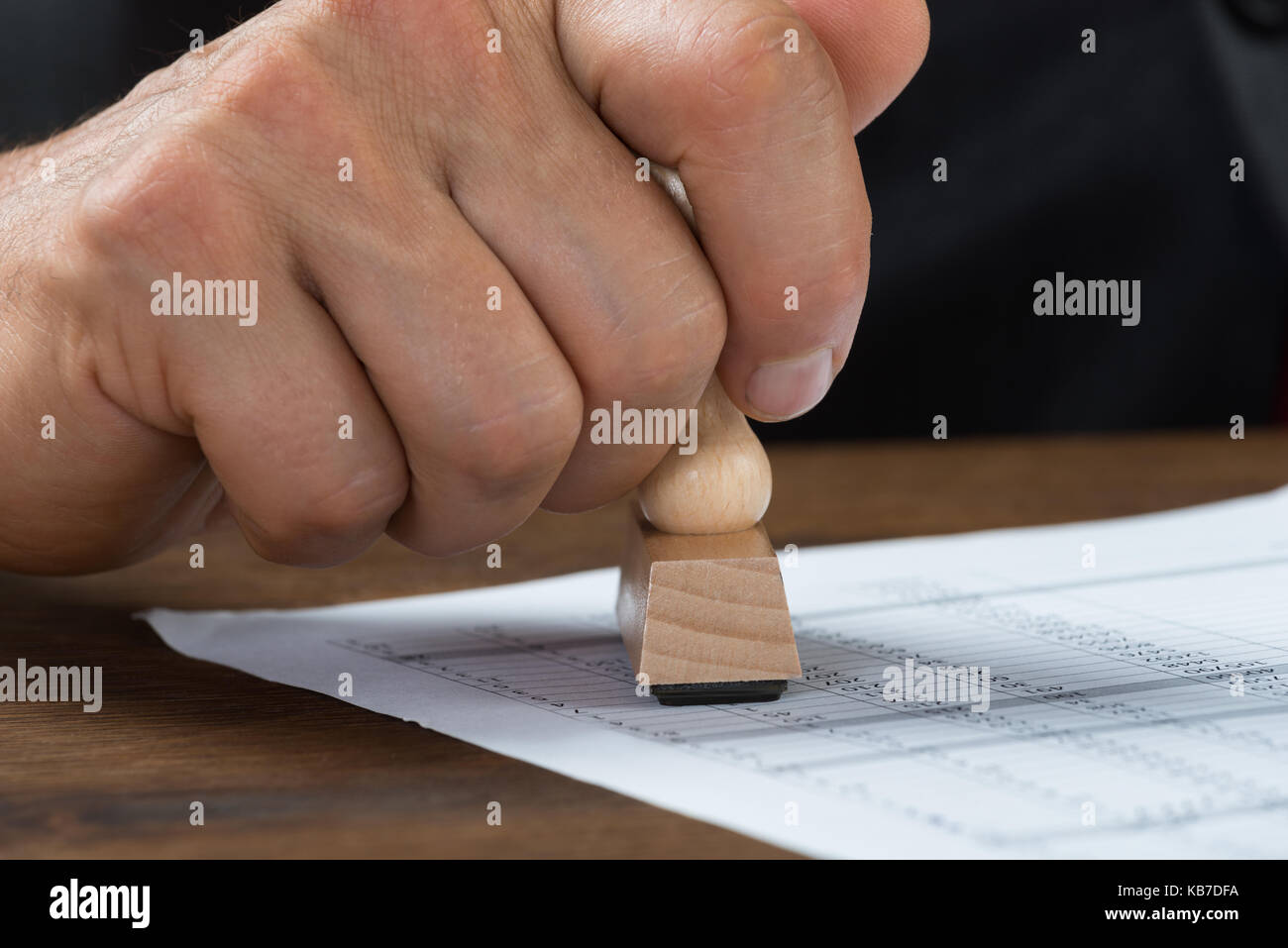 Cropped image of businessman stamping document at desk Stock Photo - Alamy