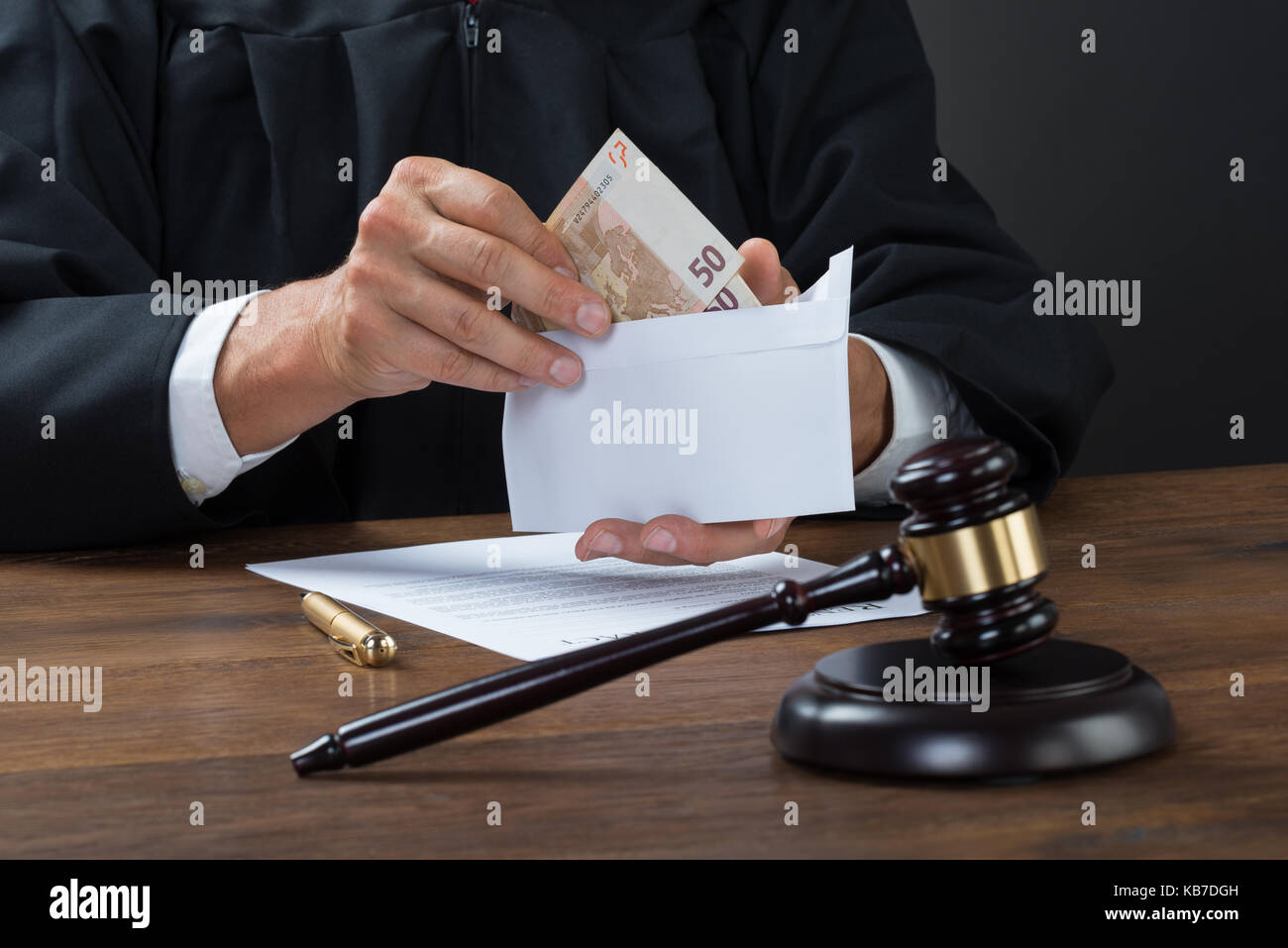 Midsection of judge removing money from envelope in courtroom Stock ...