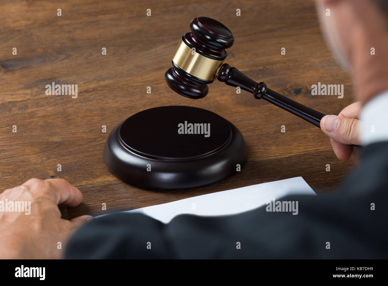 Cropped image of male judge striking the gavel at table Stock Photo - Alamy