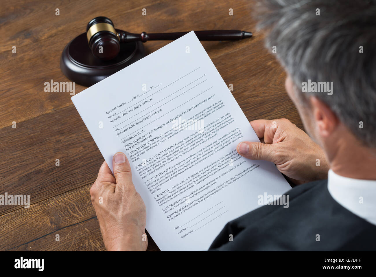 Rear view of judge reading document at table in courtroom Stock Photo ...