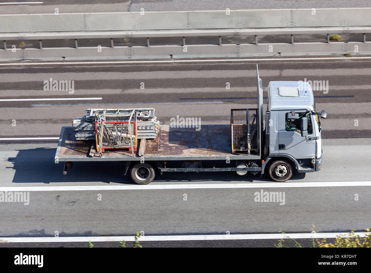 Flatbed truck loaded with scaffolds driving on the highway Stock Photo ...