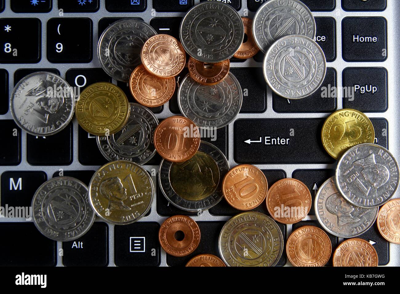 Photo of different coins on a laptop computer keyboard Stock Photo - Alamy