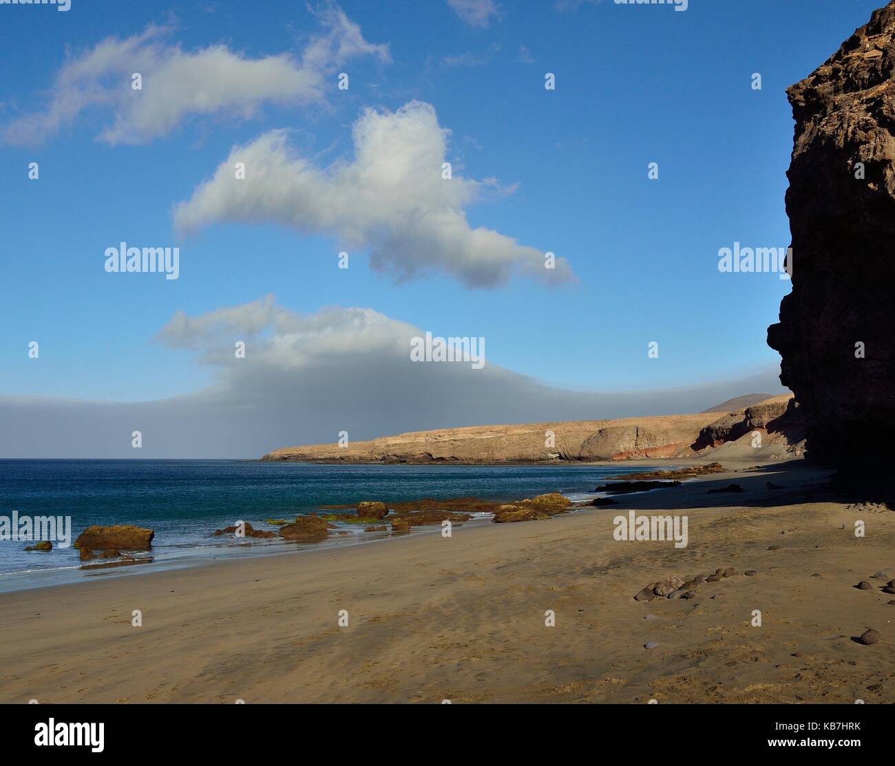 Sandy beach and rocks with blue sky and clouds, Fuerteventura island ...
