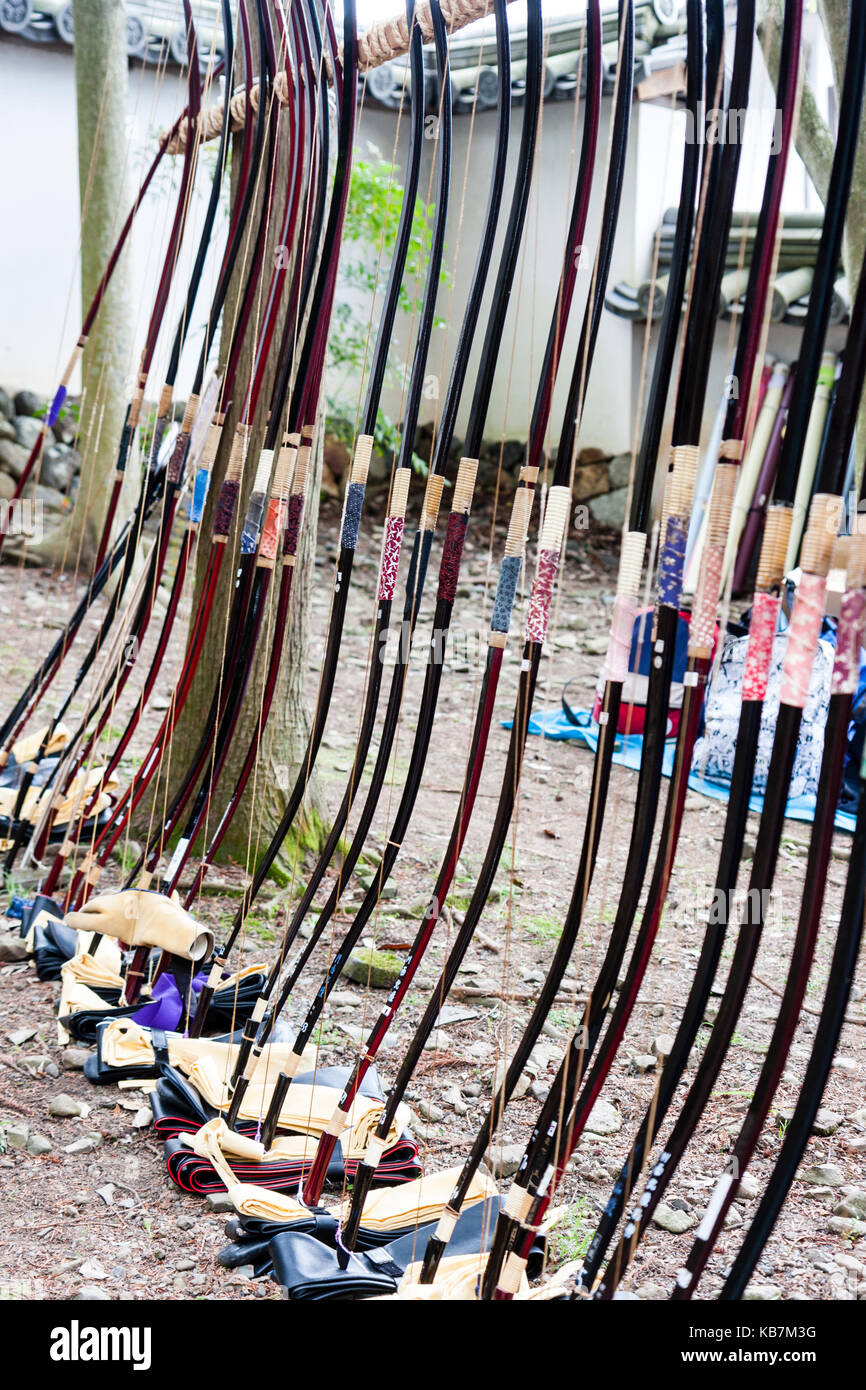 Japan, Osaka, Tada. Receeding row of ornate samurai bows stacked in a ...