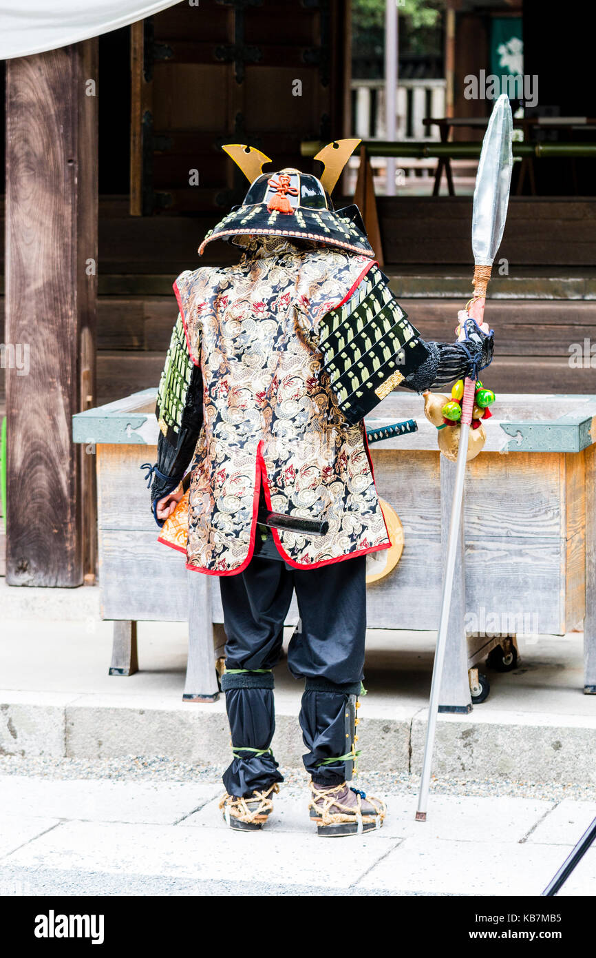 Japan, Osaka, Tada. Samurai praying in front of collection box, saisen ...