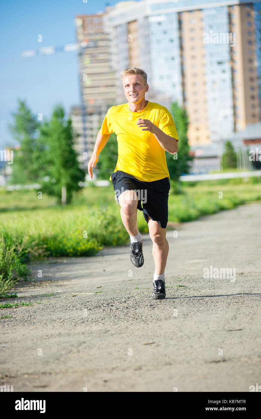 Sporty man jogging in city street park. Outdoor fitness Stock Photo - Alamy
