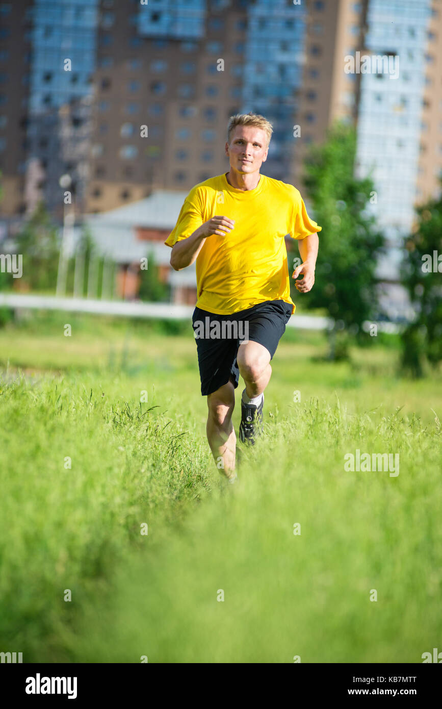 Sporty man jogging in city street park. Outdoor fitness Stock Photo - Alamy