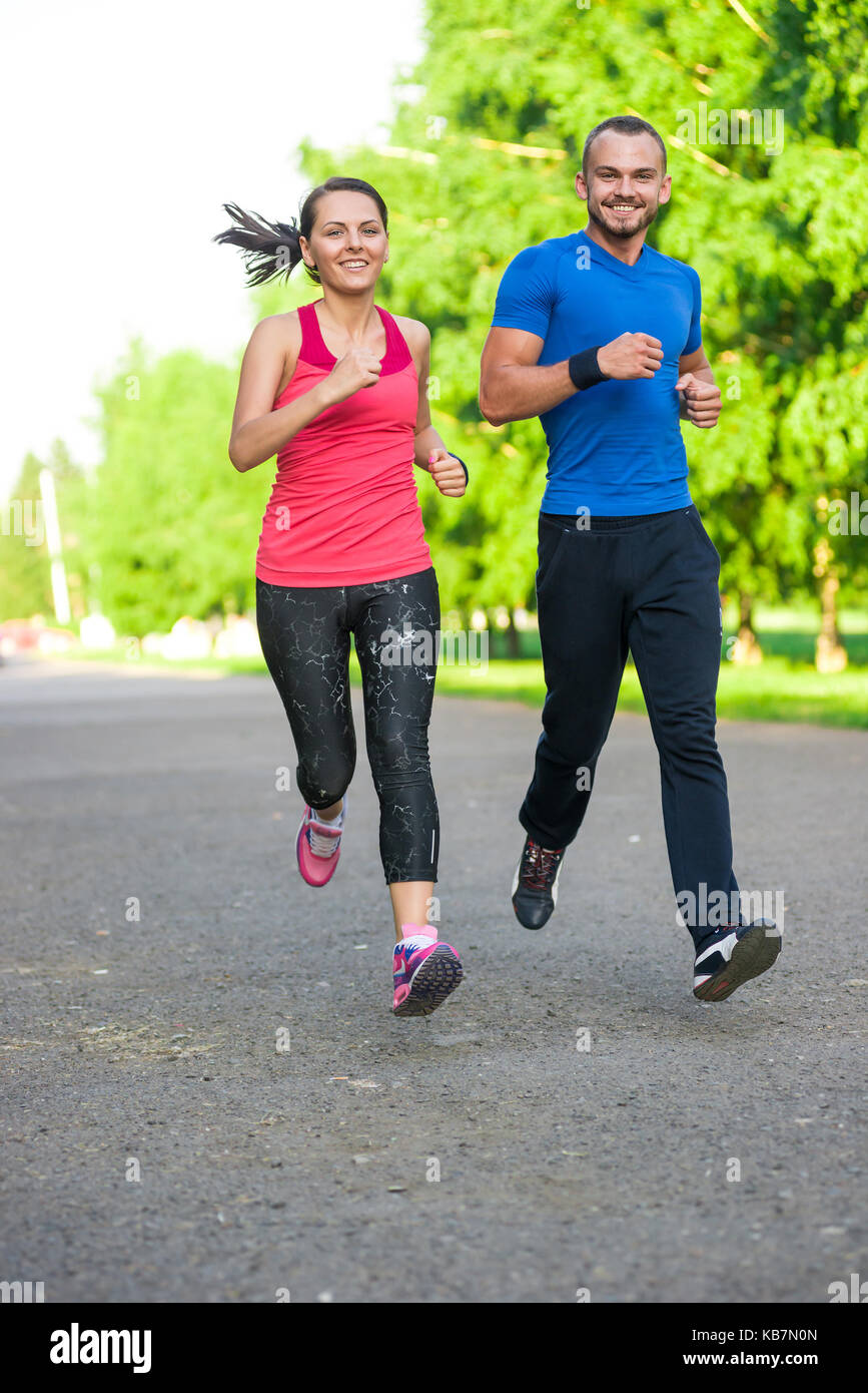 Runners training outdoors working out. City running couple jogging ...