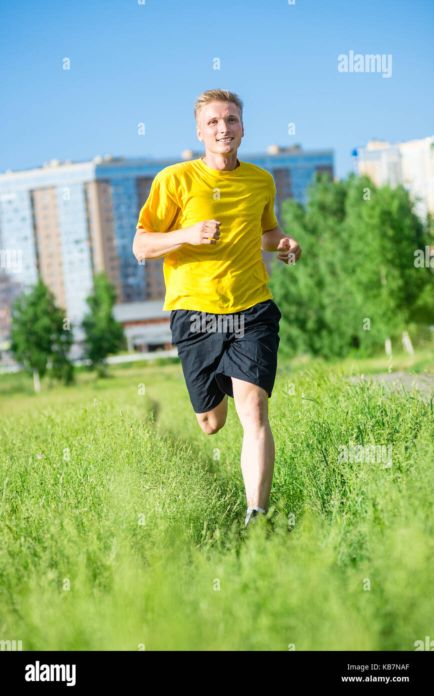 Sporty man jogging in city street park. Outdoor fitness Stock Photo - Alamy