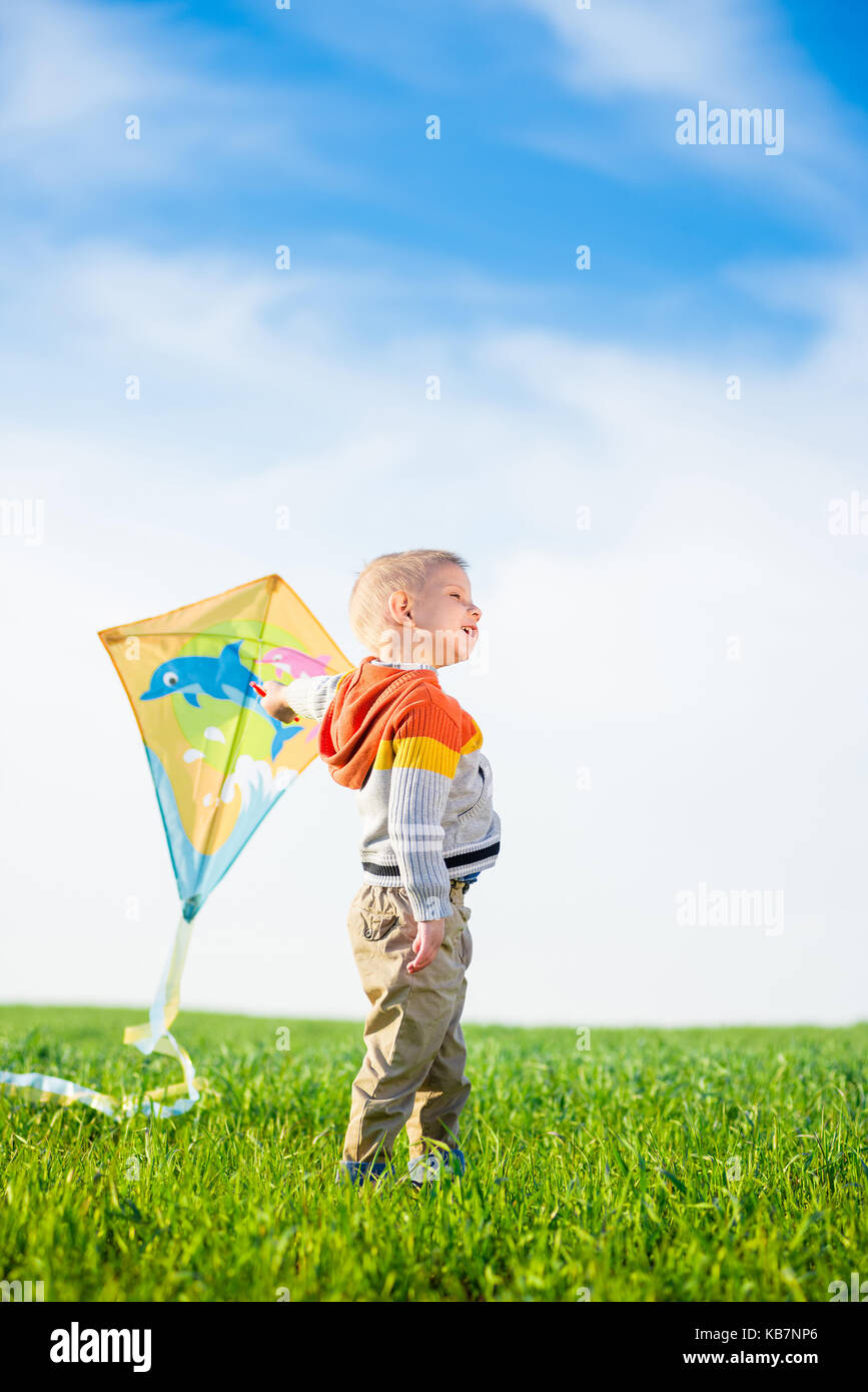 Young boy playing with his kite in a green field Stock Photo - Alamy