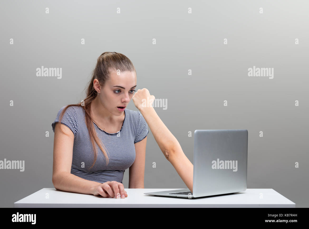 woman scared by something reaching out from her computer, that could be ...