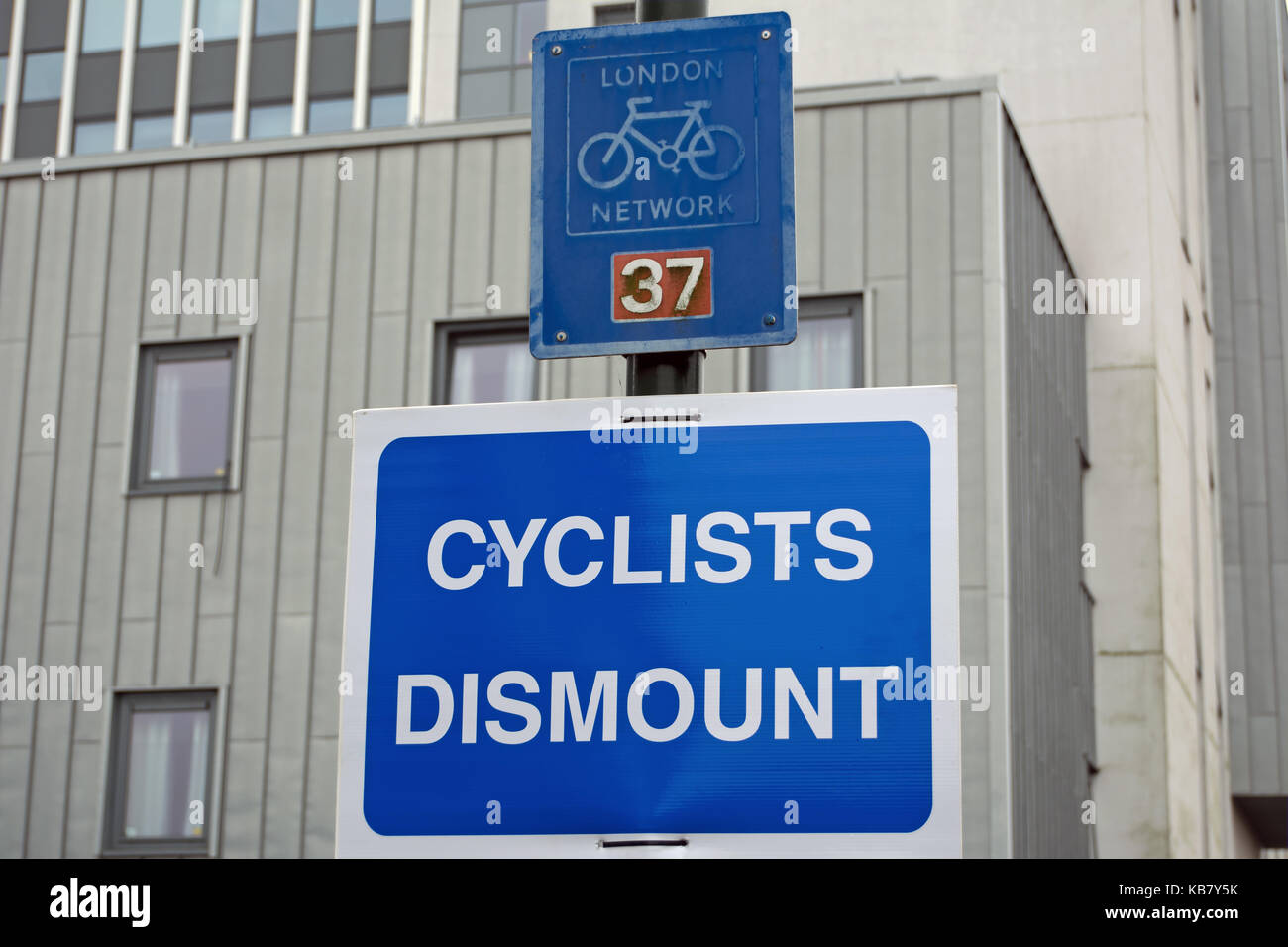 cyclists dismount sign below a london cycle network sign, in twickenham ...
