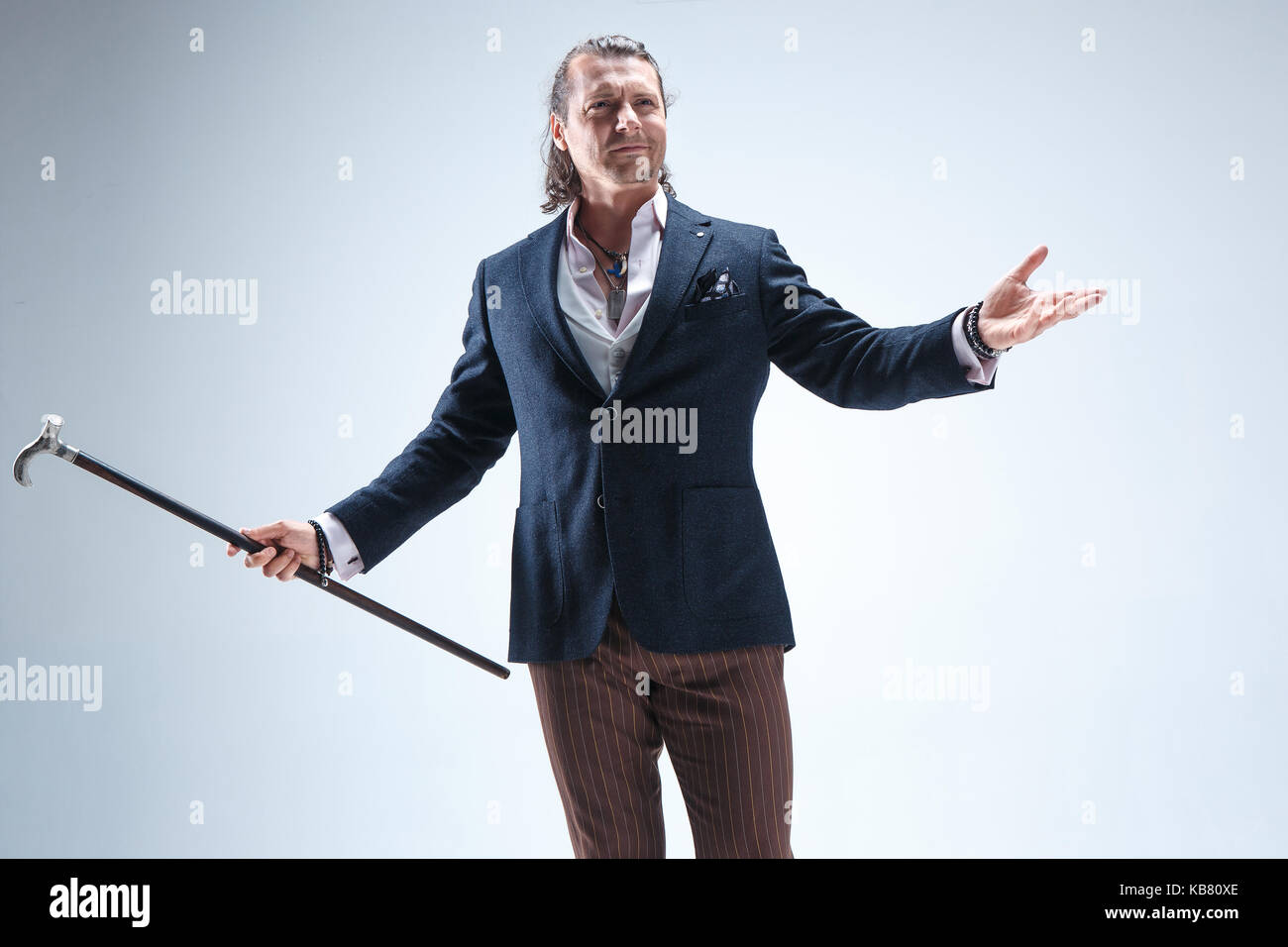 The mature barded man in a suit holding cane Stock Photo - Alamy