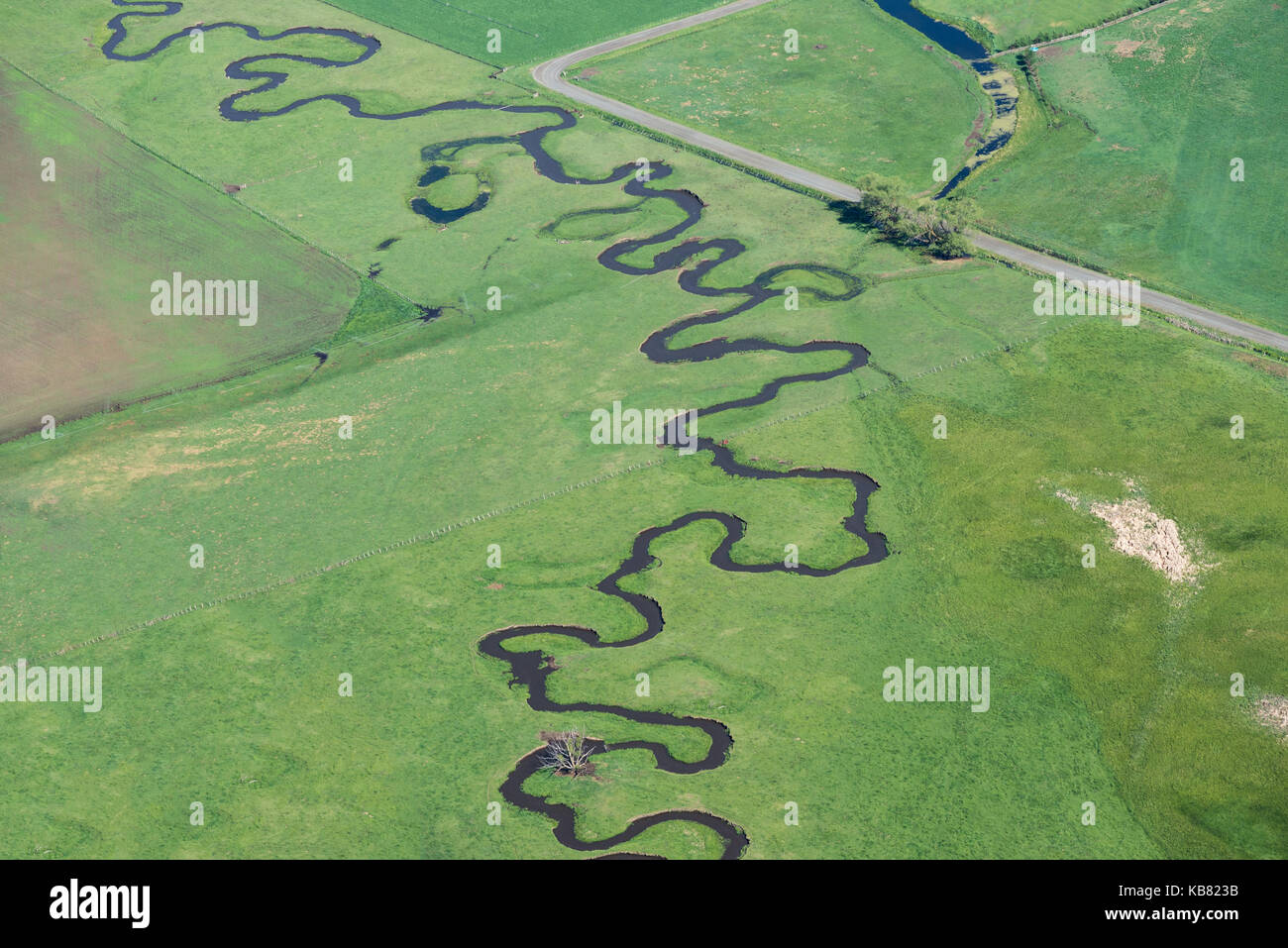 Aerial view of a stream running through pasture lands in Oregon's ...