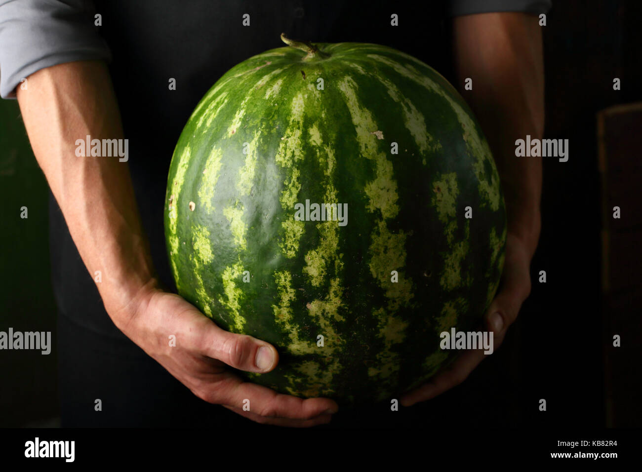 Watermelon in man's hand, food closeup Stock Photo - Alamy